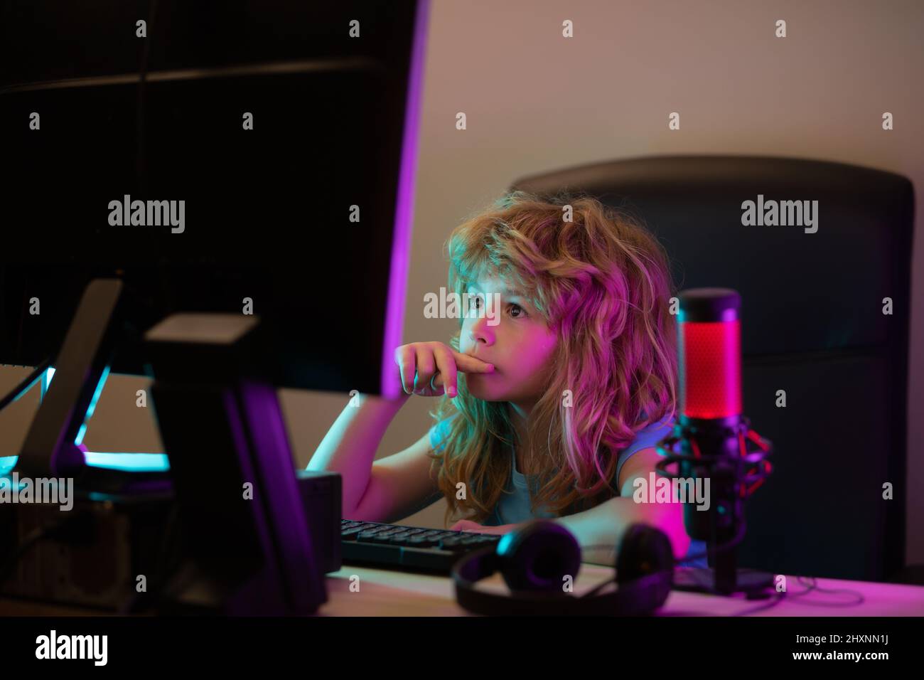 Little child blogger. A pretty child learns a lesson using a desktop ...