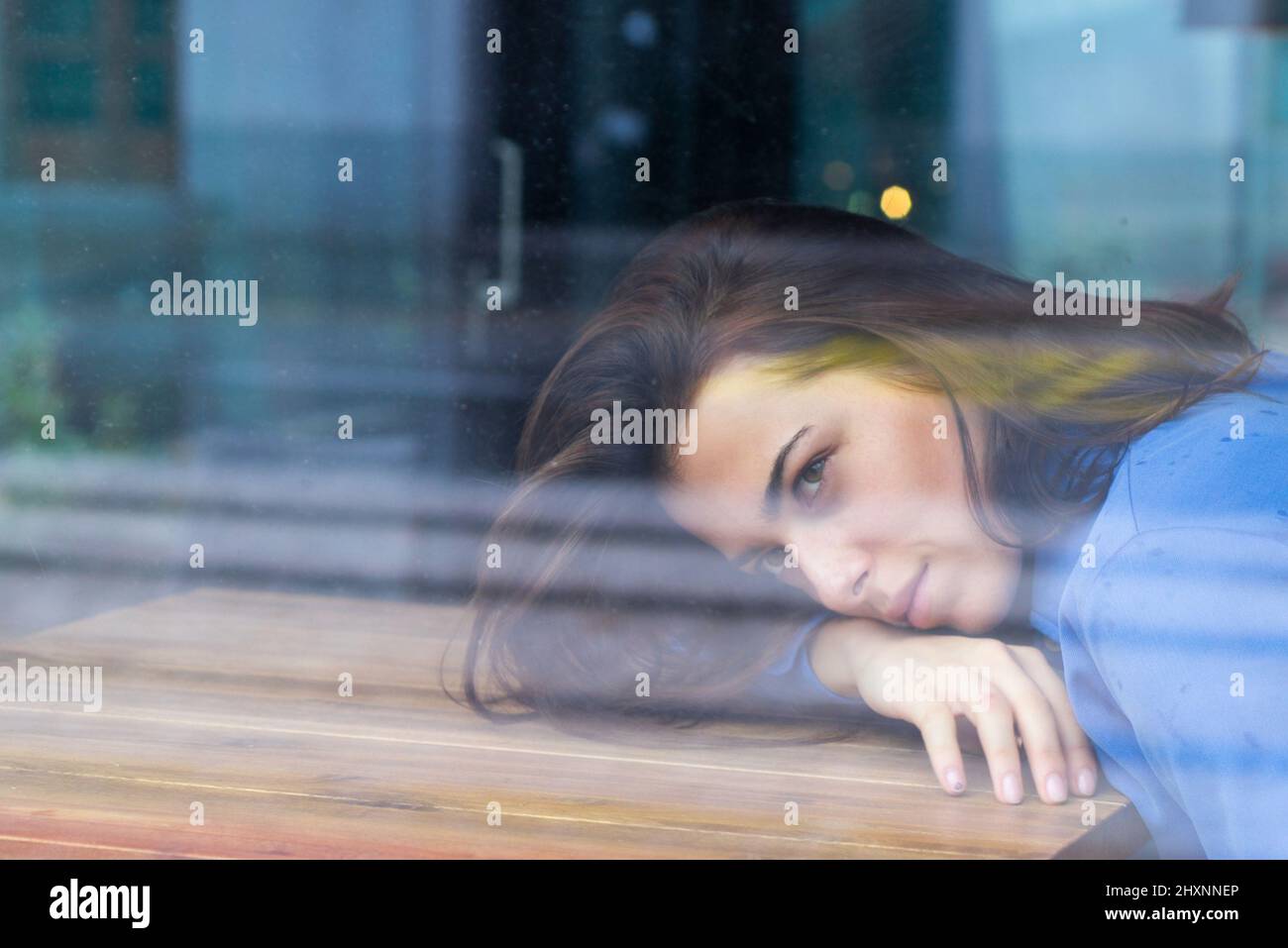 Girl in the window watching. Woman at a cafe while gazing through the ...