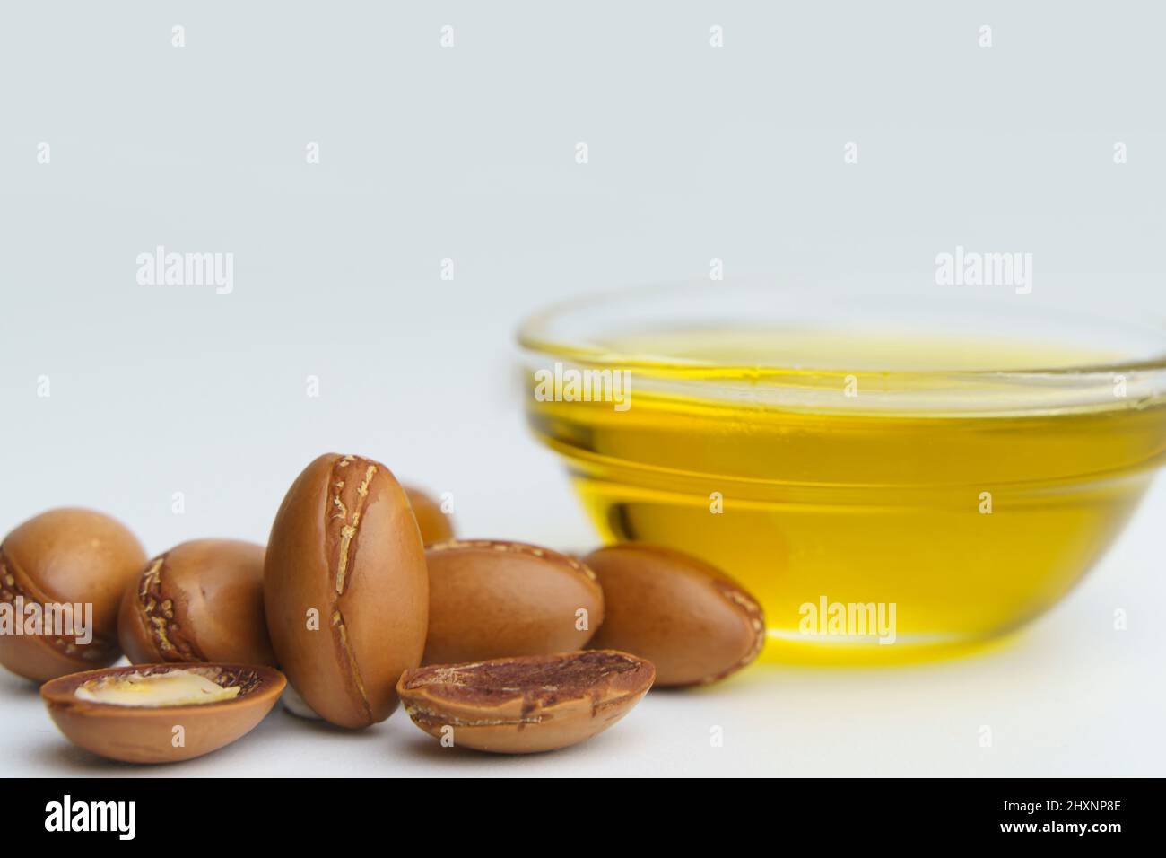 Argan seeds and oil isolated on a white background. Argan oil nuts with ...