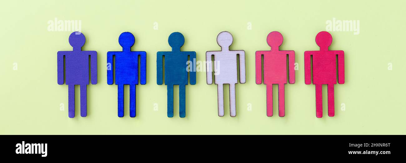 Multi-colored wooden figurines of man on yellow background. Individual ...