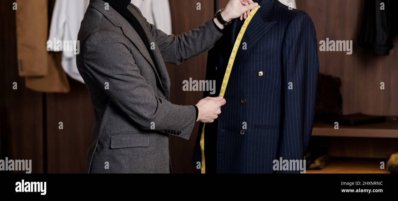 man taking measures from jacket. tailor in the workshop at work Stock ...