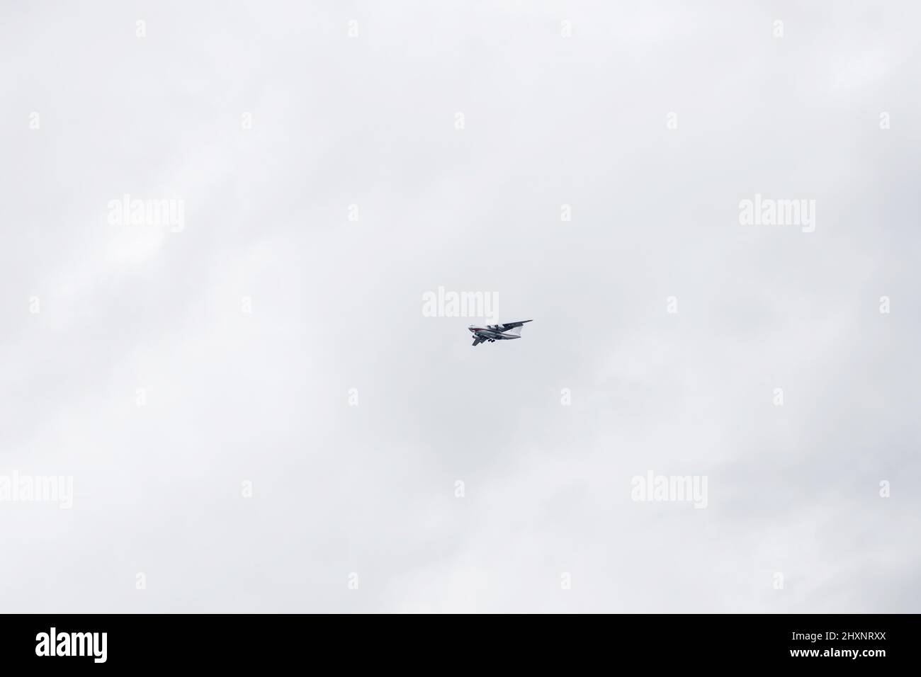 The fly of white aircraft in gray sky. flight Stock Photo - Alamy