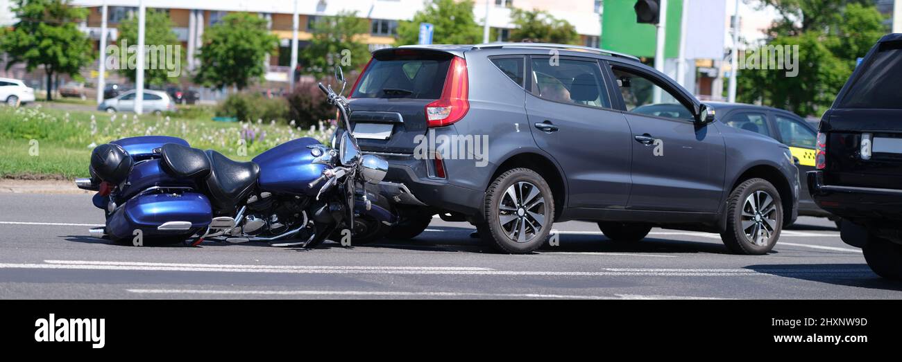 Motorcycle crashed into back of car on road closeup Stock Photo - Alamy