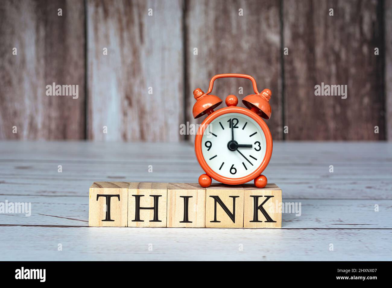 Think text on wooden blocks and alarm clock set at 3 o'clock on table ...