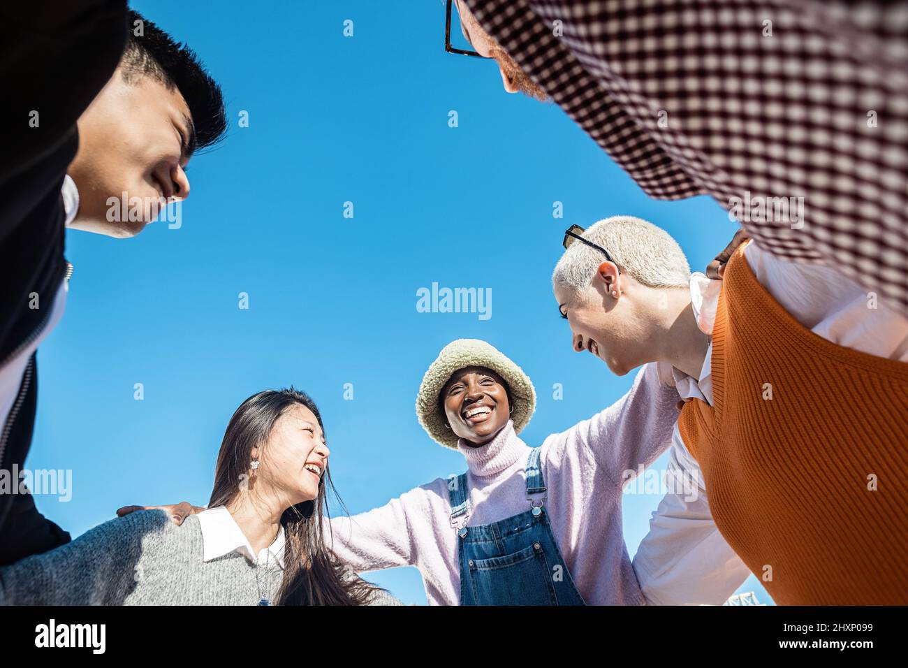 United multiethnic group of friends hugging each other outdoors Stock ...
