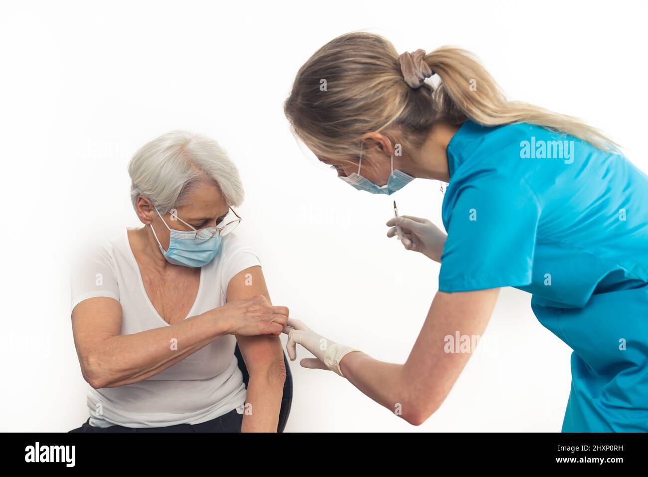 Pensioner woman in her 70s gets a vaccine booster. Copy space. White ...