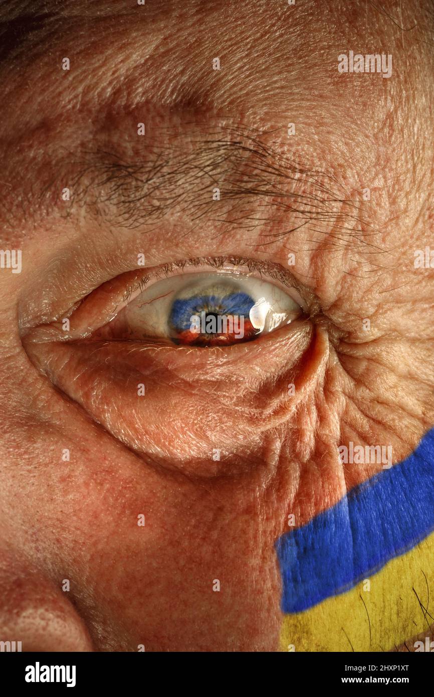 Close-up male eye with colors of Ukraine flag on his cheek. Stop war ...