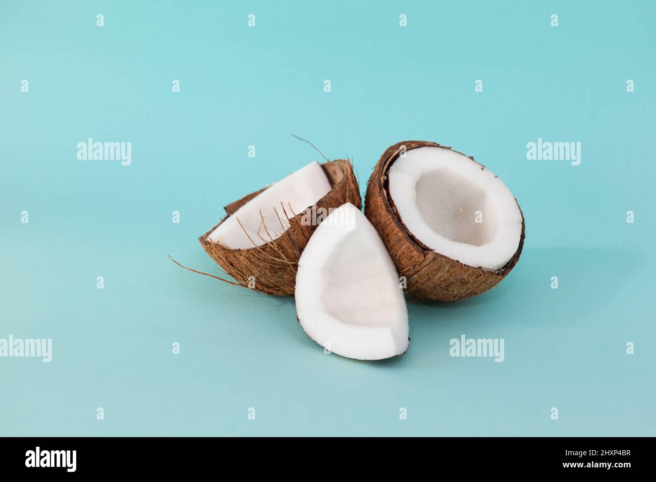 Fresh coconut pieces on the aqua blue background Stock Photo - Alamy