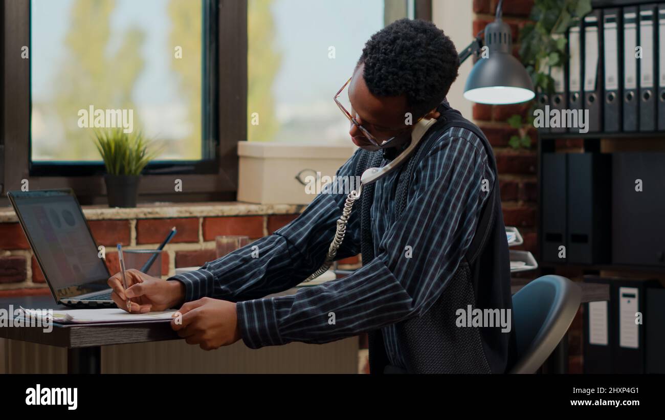 Office worker using landline phone to answer business call, discussing ...