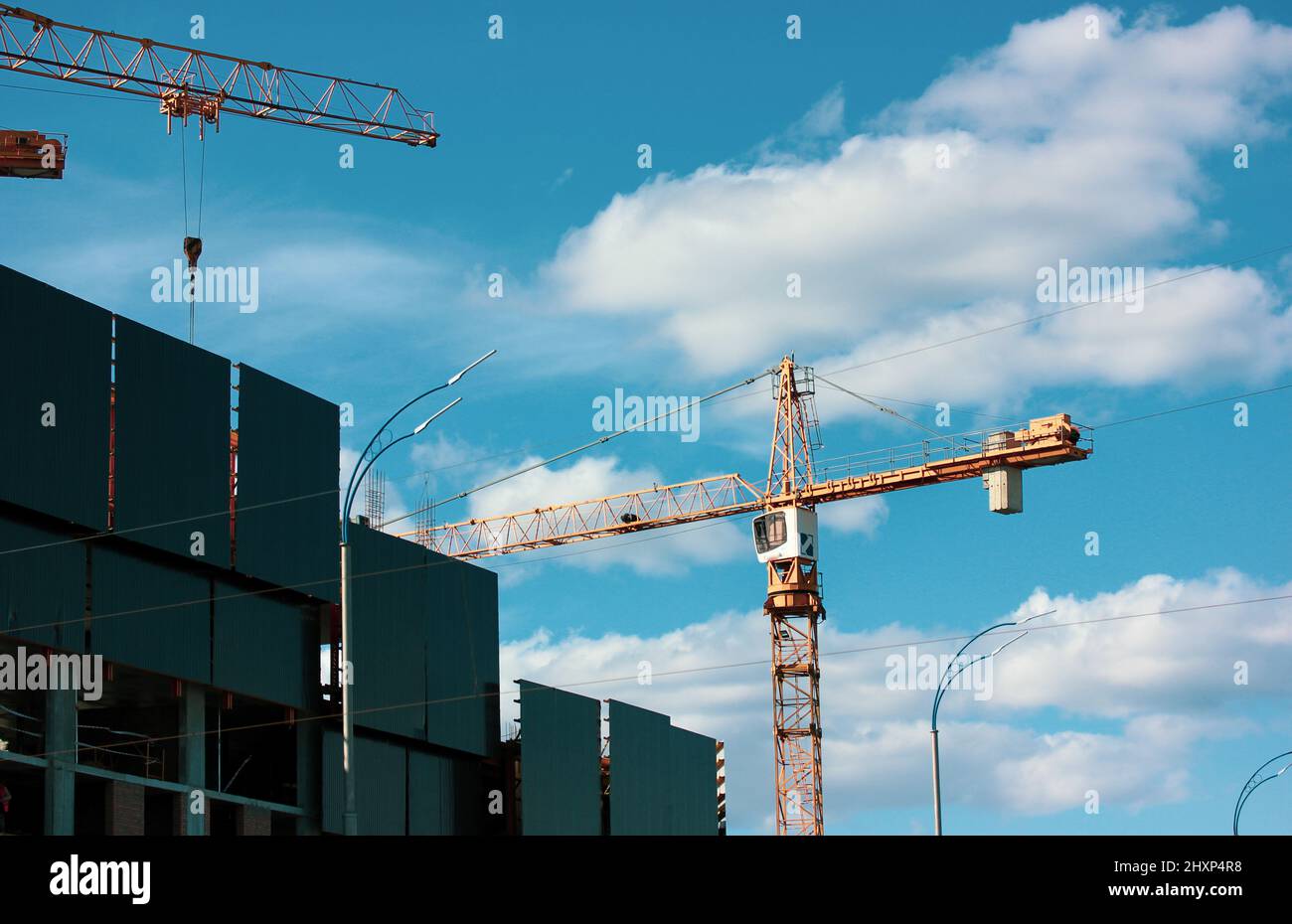 Construction crane against blue cloudy sky at construction site ...