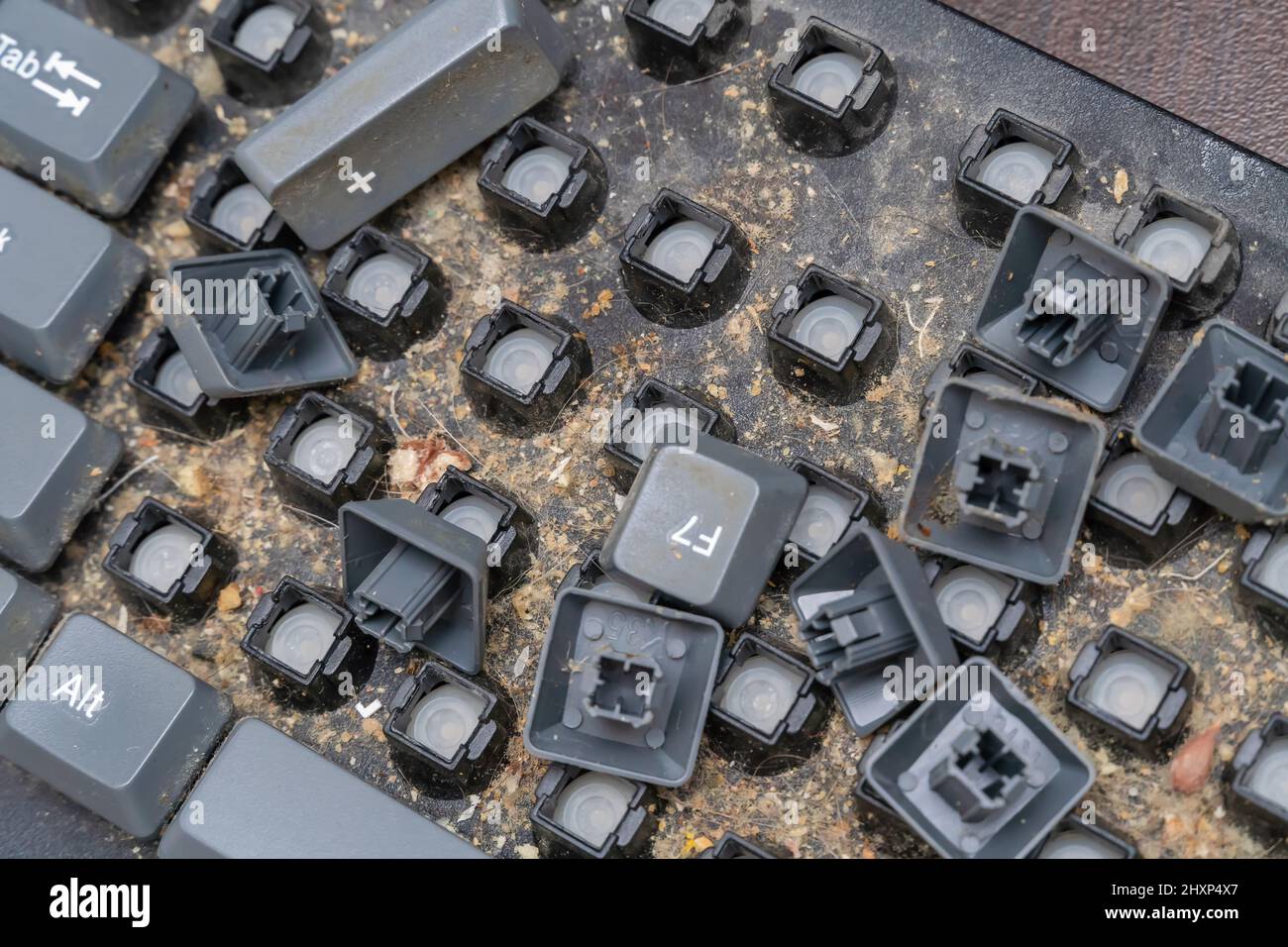 Close-up of a very dirty disassembled computer keyboard on the table ...