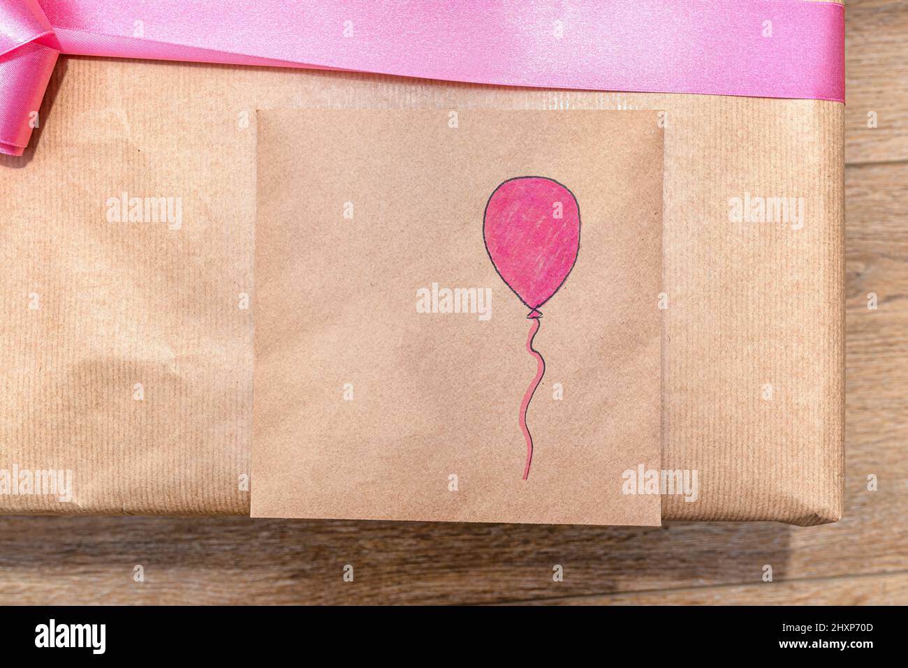 Gift wrapped in gray paper wrapped with a pink ribbon, closeup on a ...