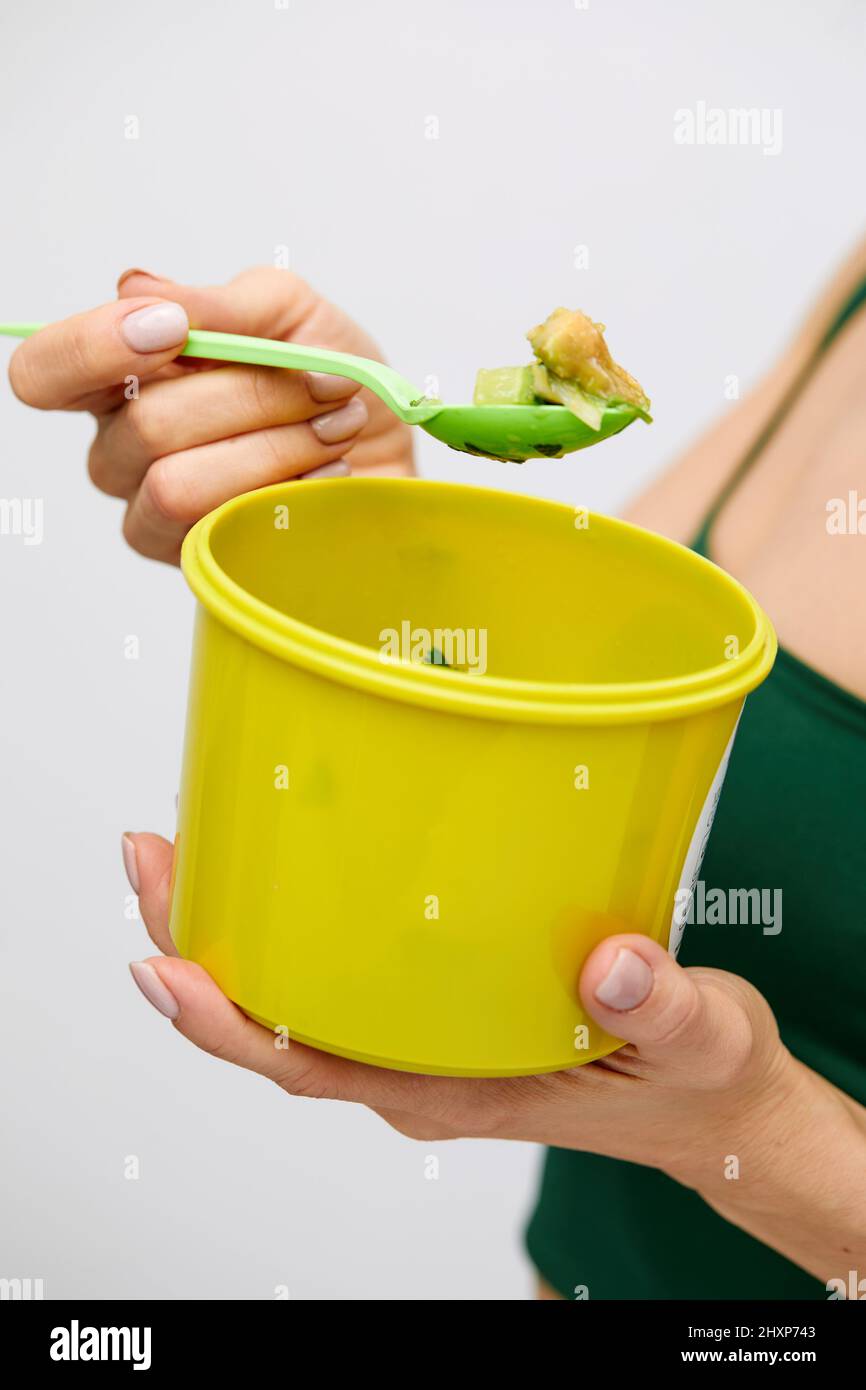 Young model healthy woman eating green vegetables avocado, cucumber and ...