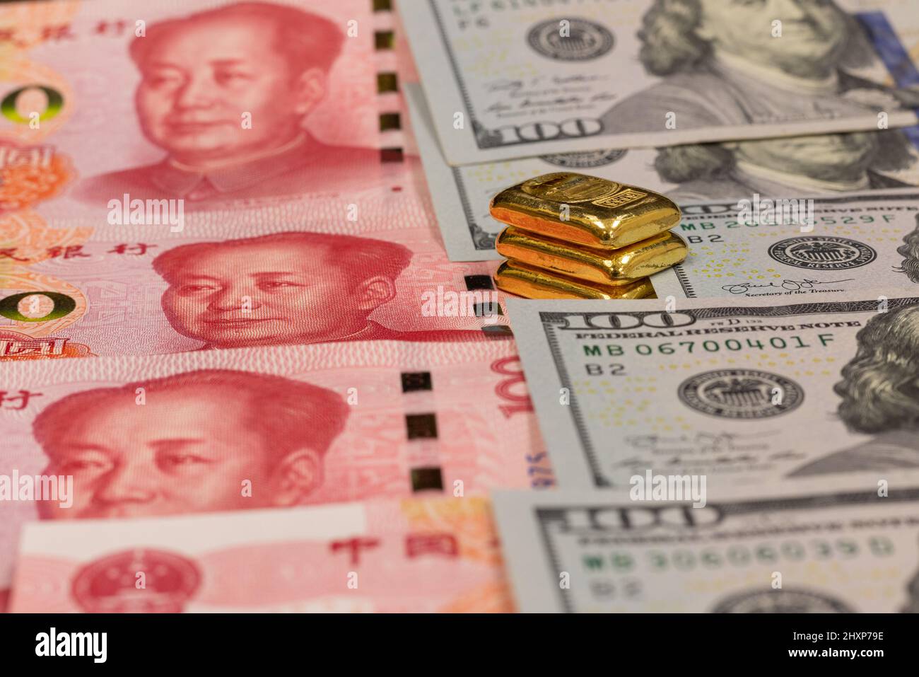 pile of pure gold bars, bullion, ingot on background of Renminbi, or ...