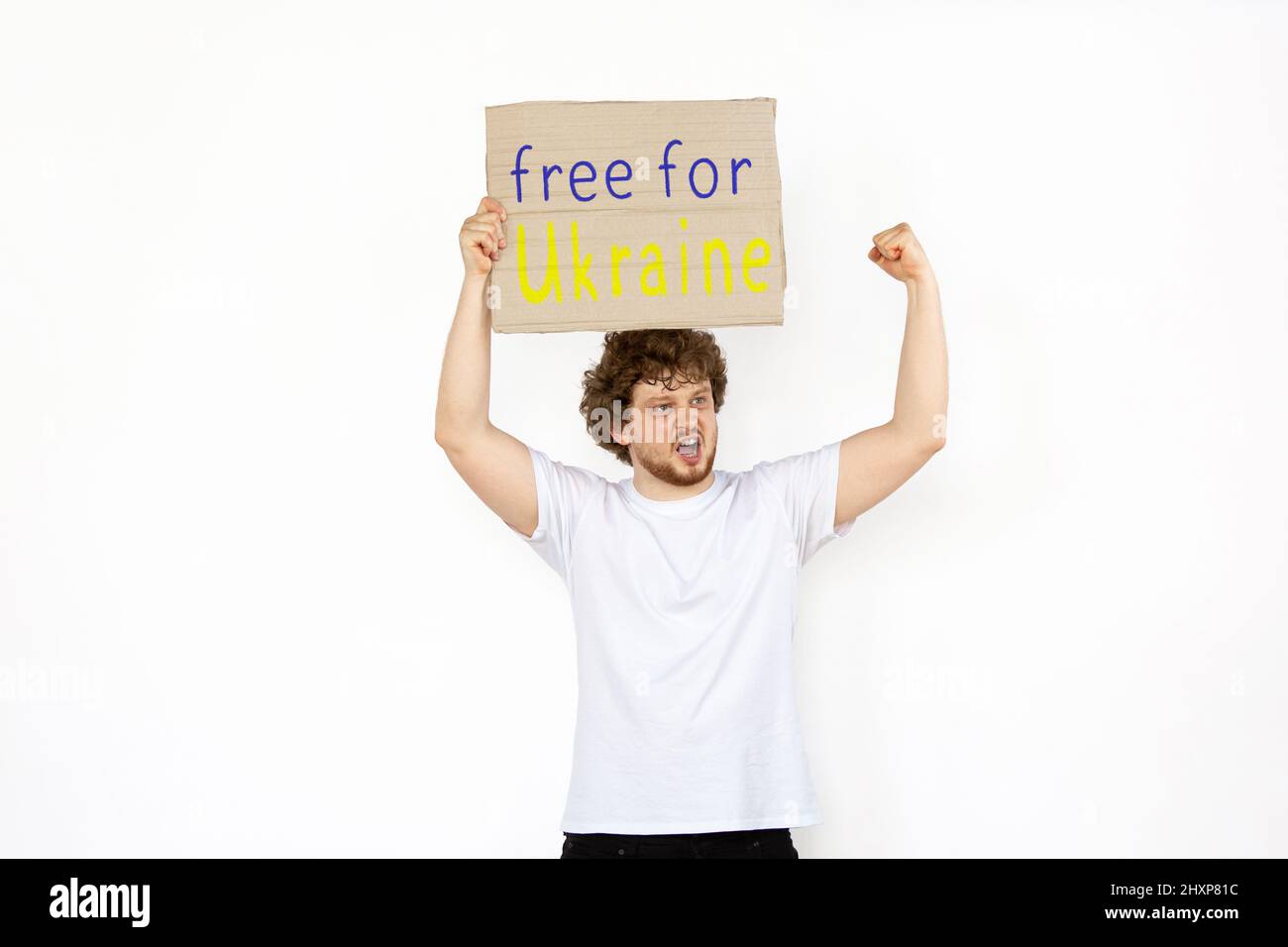 Conceptual portrait of emotional young man shouting, holding poster ...