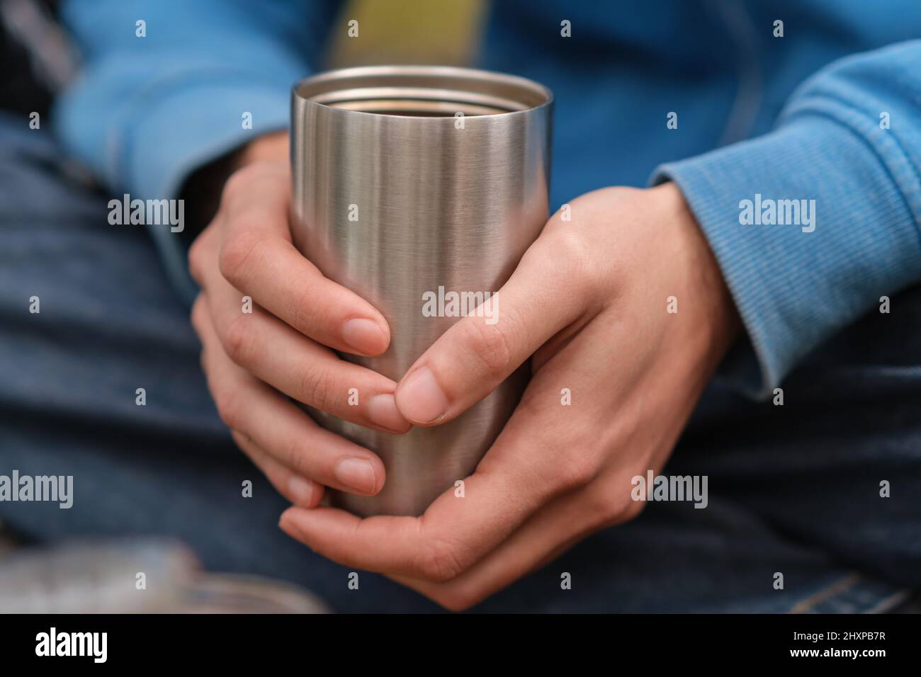 Insulated stainless steel cup in hands Stock Photo - Alamy