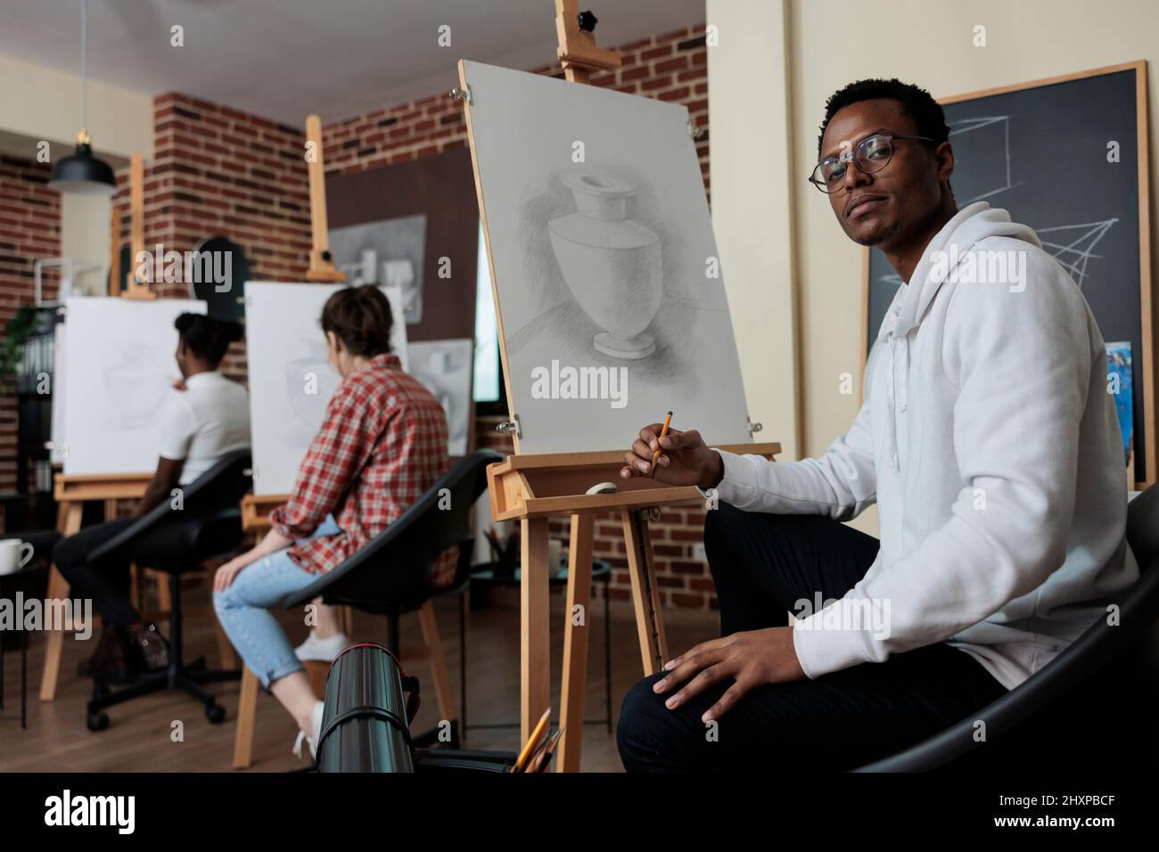 Portrait of smiling painter student attenting drawing class developing ...