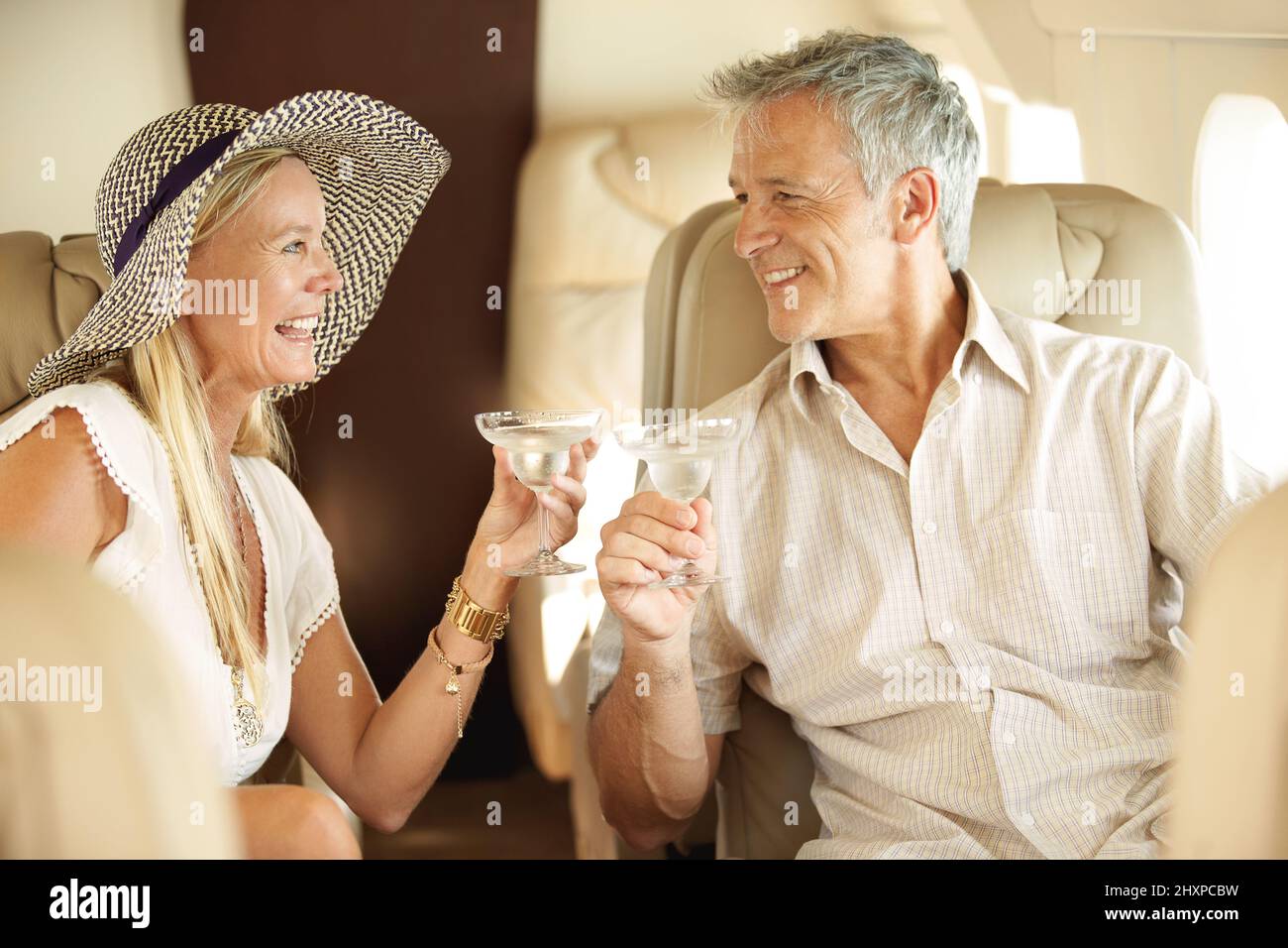 Bonding on a romantic getaway. Smiling and happy couple seated in a ...