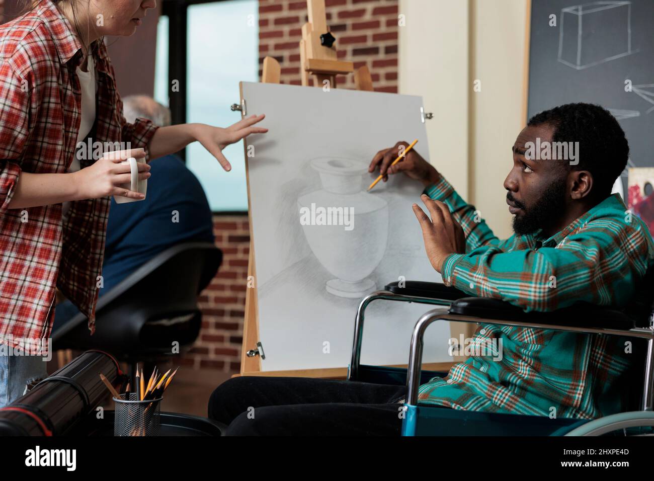 Painter teacher showing drawing technique to impaired student with ...