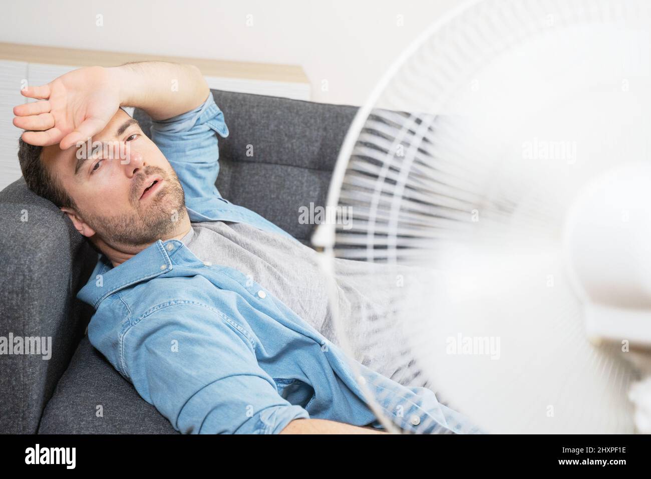 One man sweating suffering summer heatwave at home Stock Photo - Alamy