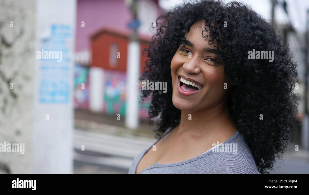 A joyful happy Brazilian woman turning head to camera laughing Stock ...