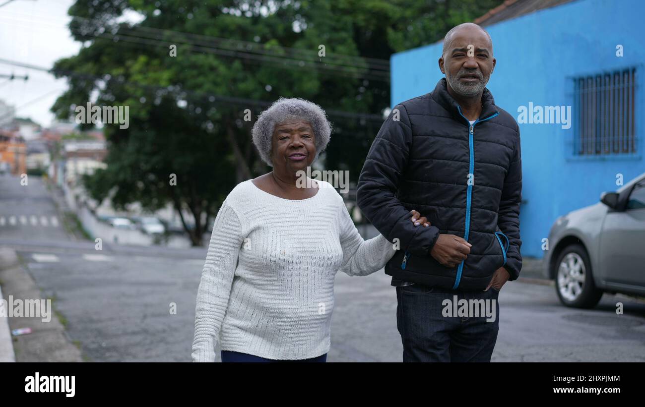 A son and senior mother walking together in street 80s parent Stock ...