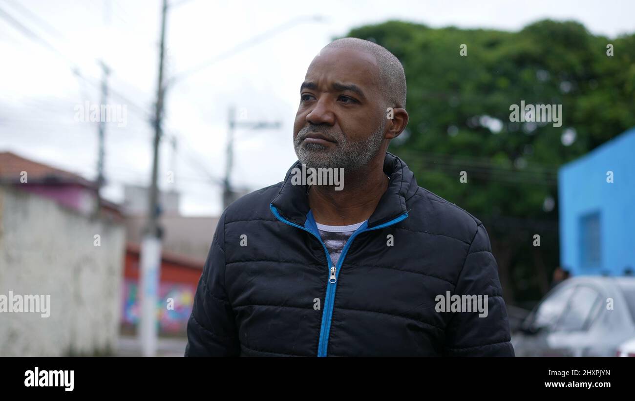 An introspective African man walking outside in street a contemplative ...