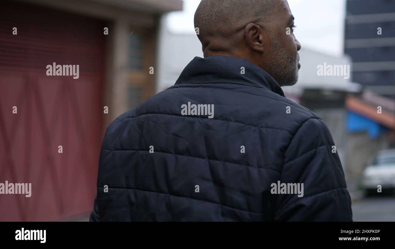 An introspective African man walking outside in street a contemplative ...
