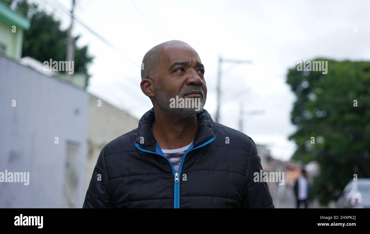 An introspective African man walking outside in street a contemplative ...