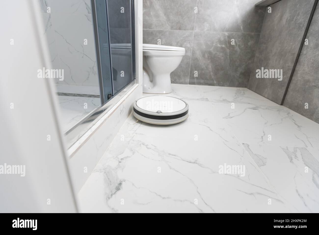 White robot vacuum cleaner in bathroom Stock Photo - Alamy