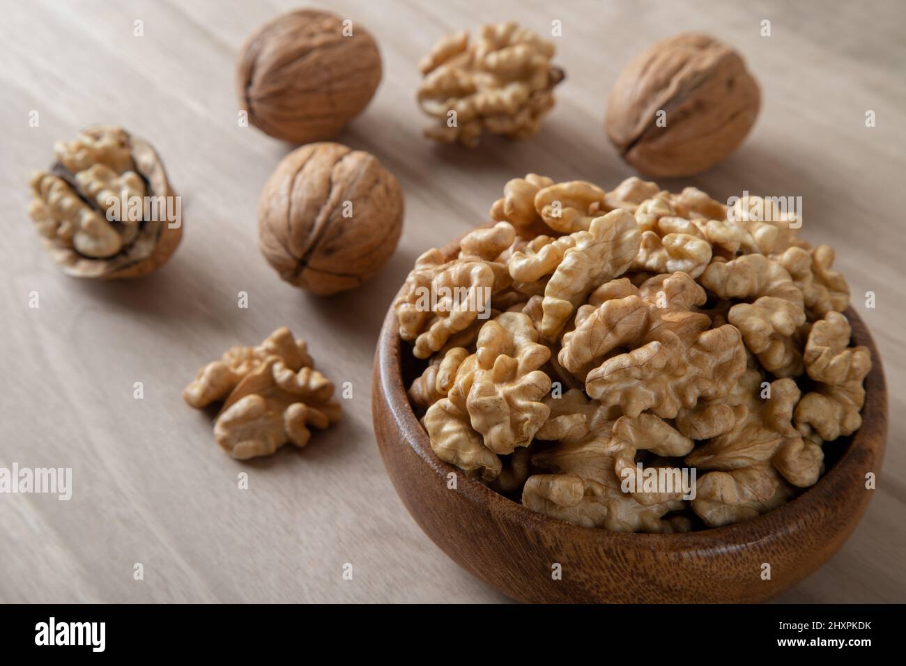 Bowl of walnuts and whole walnut kernels on wooden background,top view ...