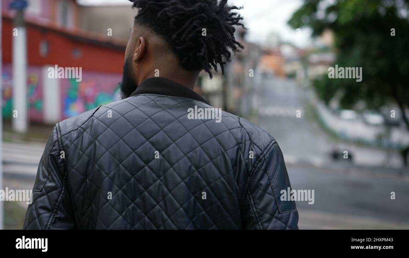 One young man walking outside in urban street person walks forward ...