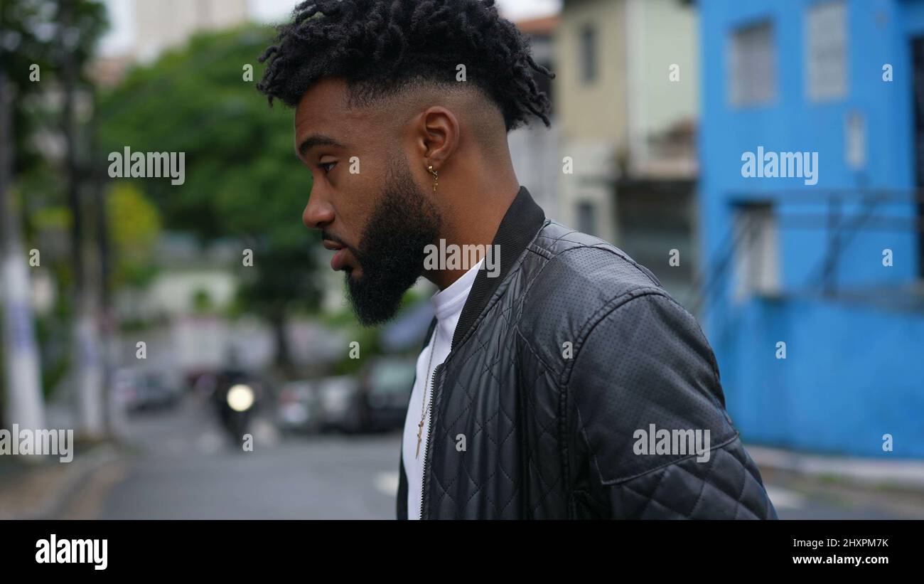 One young man walking outside in urban street person walks forward ...