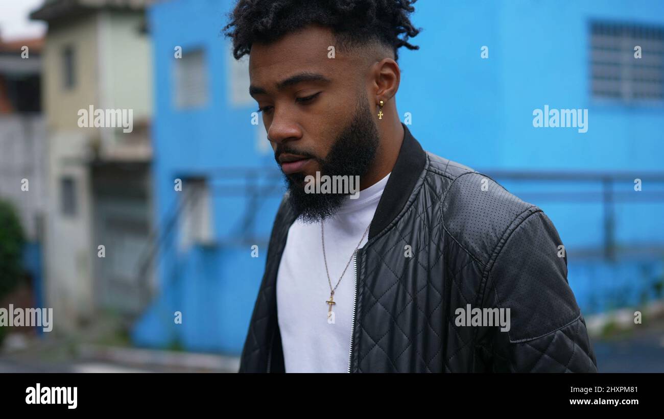 One young man walking outside in urban street person walks forward ...