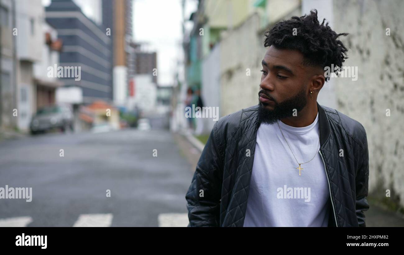 One young man walking outside in urban street person walks forward ...