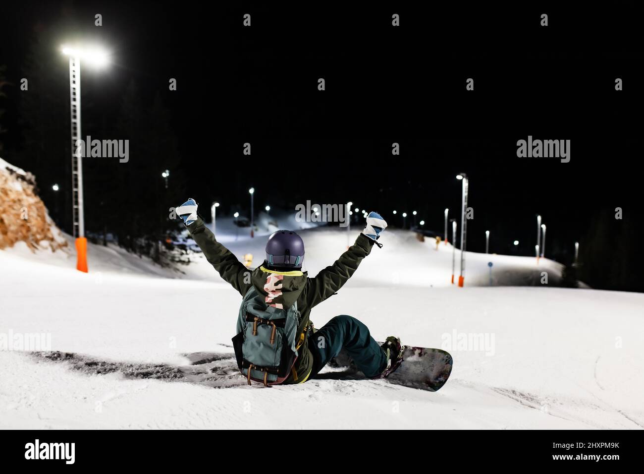 Snowboarder girl posing on slopes. Night skiing in winter resort Stock ...