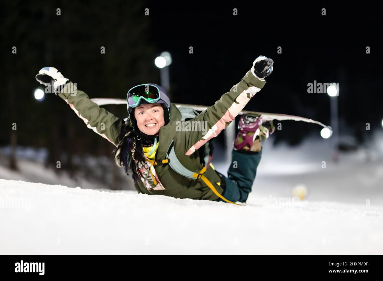 Snowboarder girl posing on slopes. Night skiing in winter resort Stock ...