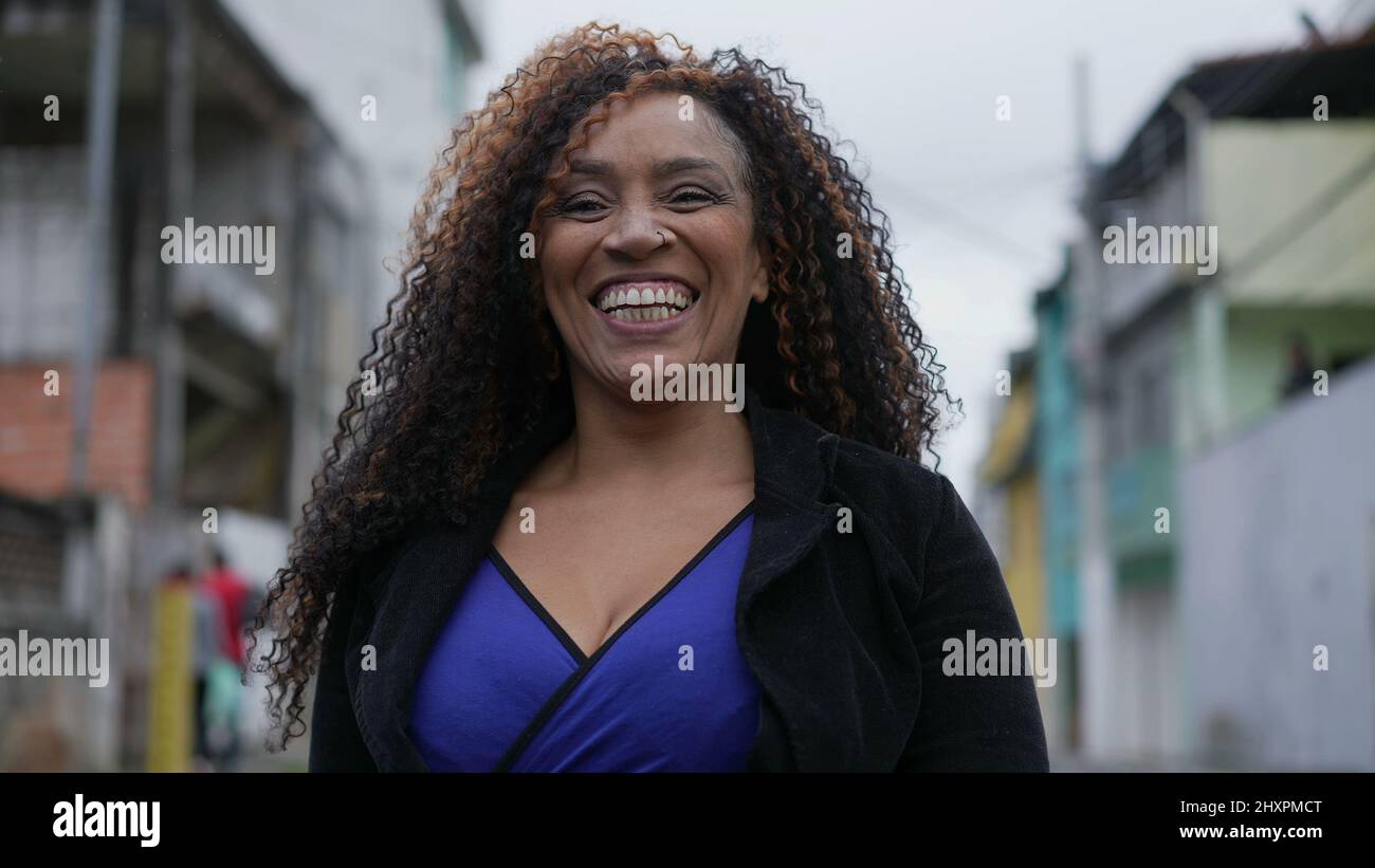 Portrait of a happy Brazilian latin woman walking in street outside ...