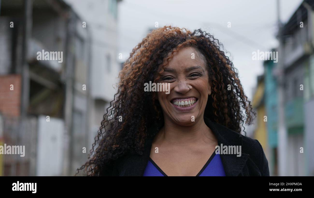 Portrait of a happy Brazilian latin woman walking in street outside ...
