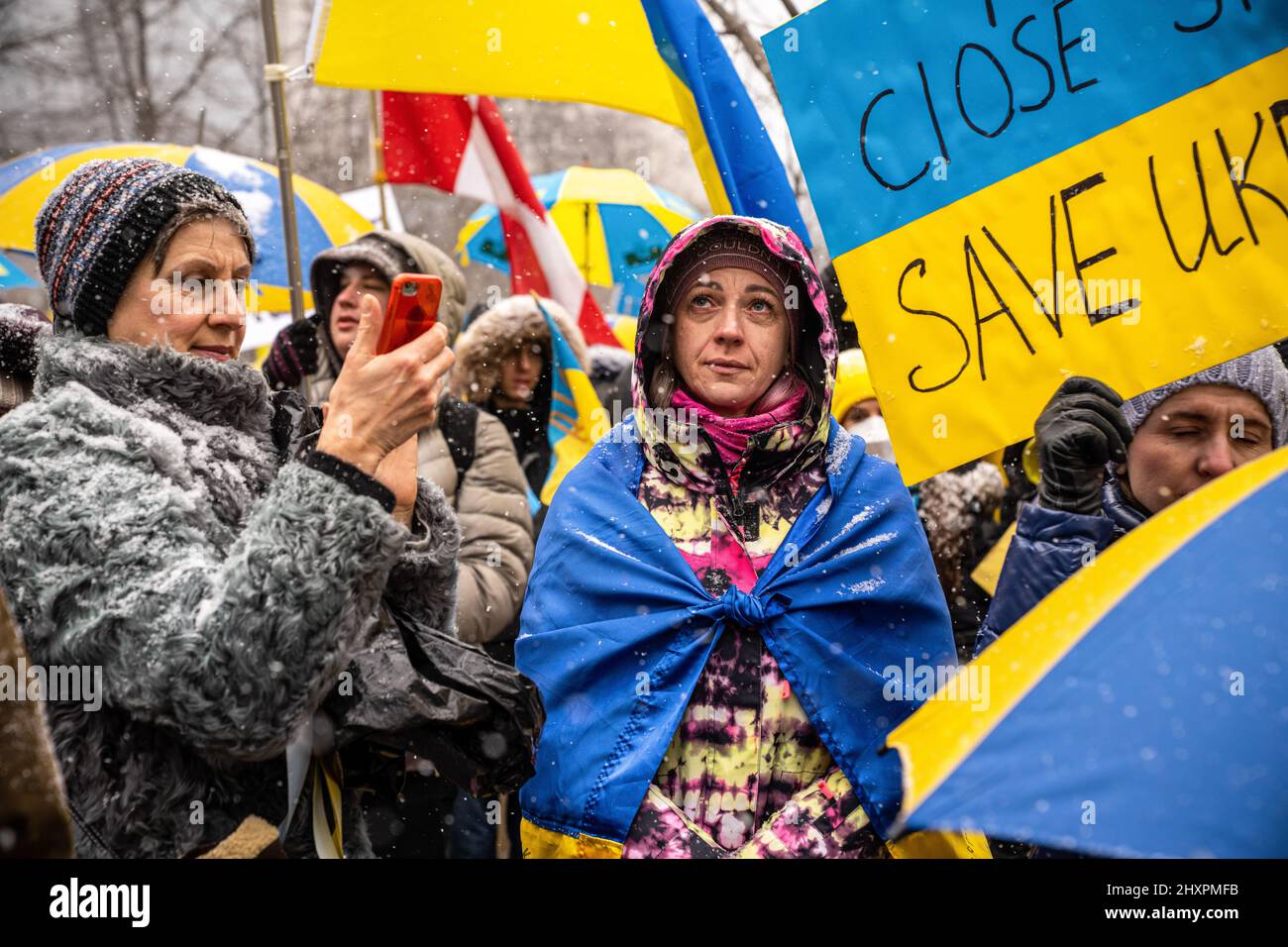 Toronto, Canada. 13th Mar, 2022. A protester looks while covering ...
