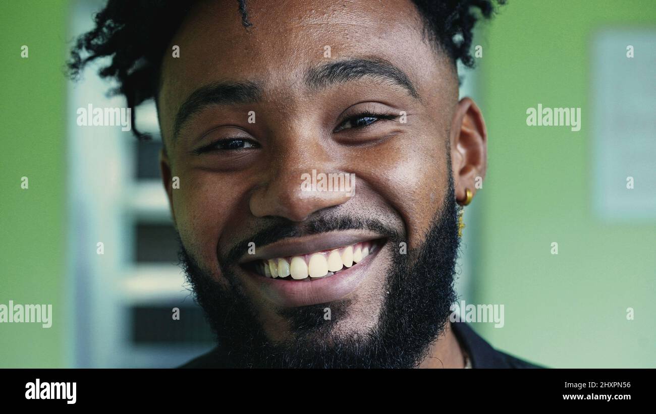 A happy black African latin man portrait face smiling and laughing ...