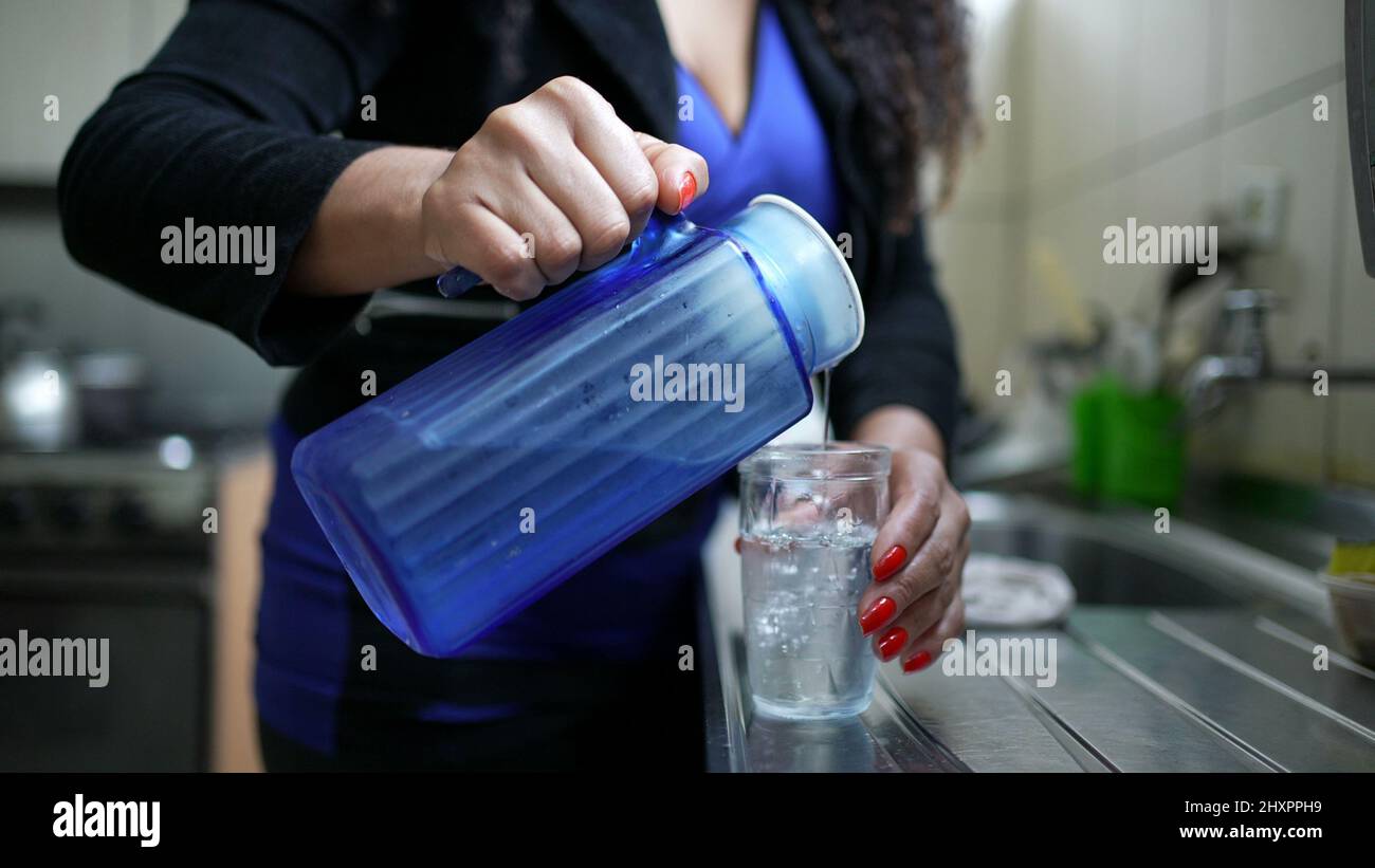Person serving water from jug woman serves water jar Stock Photo - Alamy