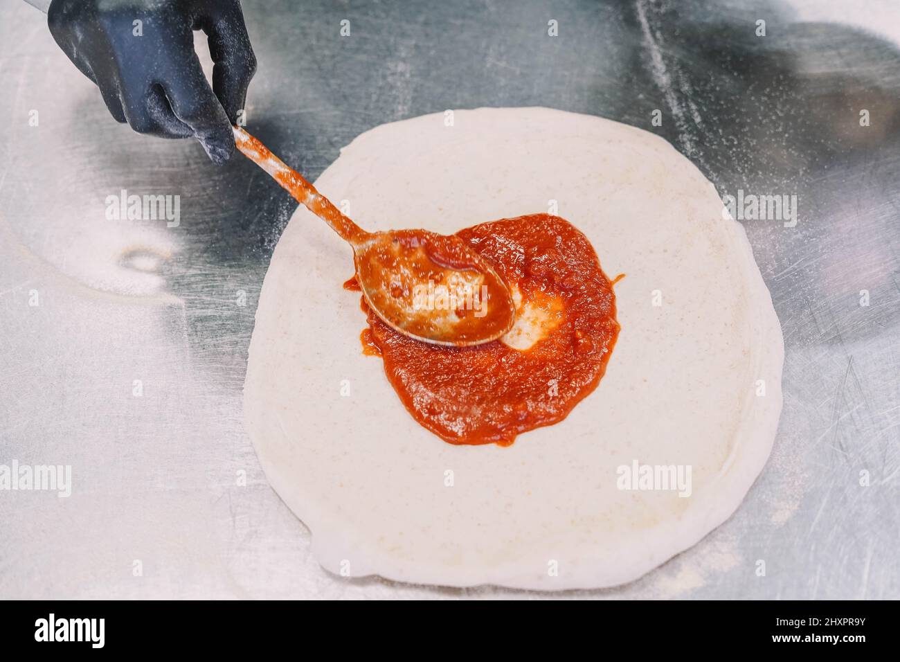 Preparation of a homemade Italian style pizza by a specialist Stock ...