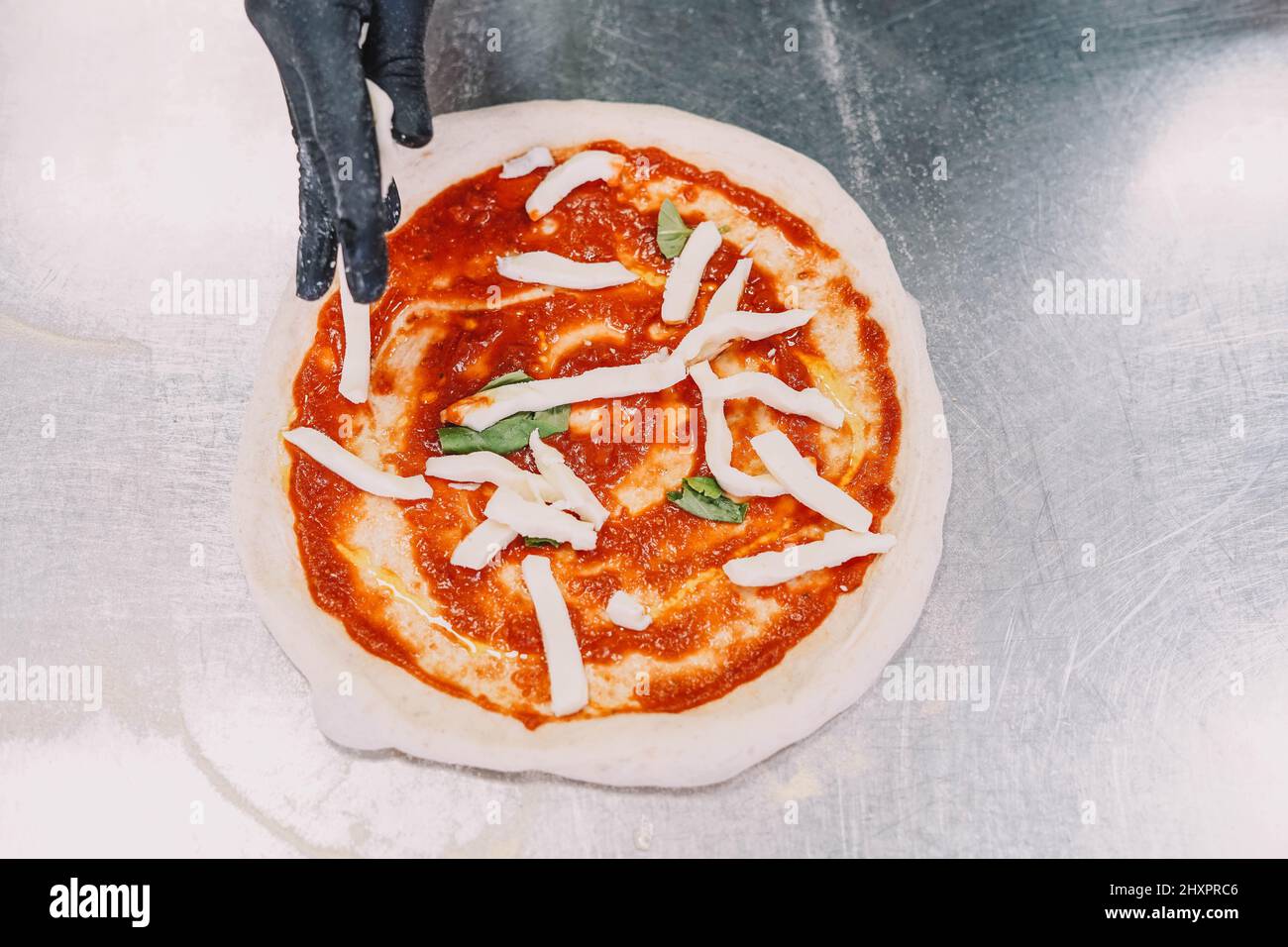 Preparation of a homemade Italian style pizza by a specialist Stock ...