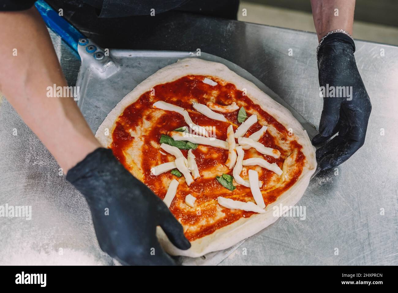Preparation of a homemade Italian style pizza by a specialist Stock ...