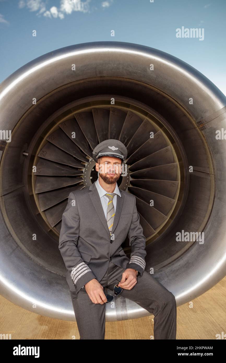 Bearded male pilot sitting in airplane engine at airport Stock Photo ...
