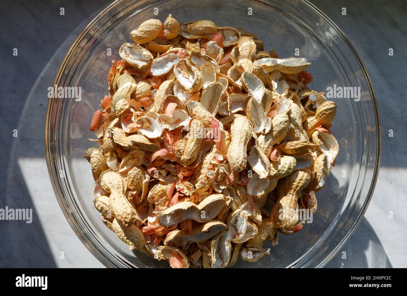 Peanut shells waste in a glass bowl Stock Photo - Alamy