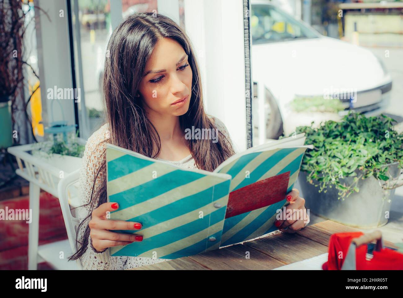 Beautiful woman looking at menu and ordering foods in restaurant. Close ...