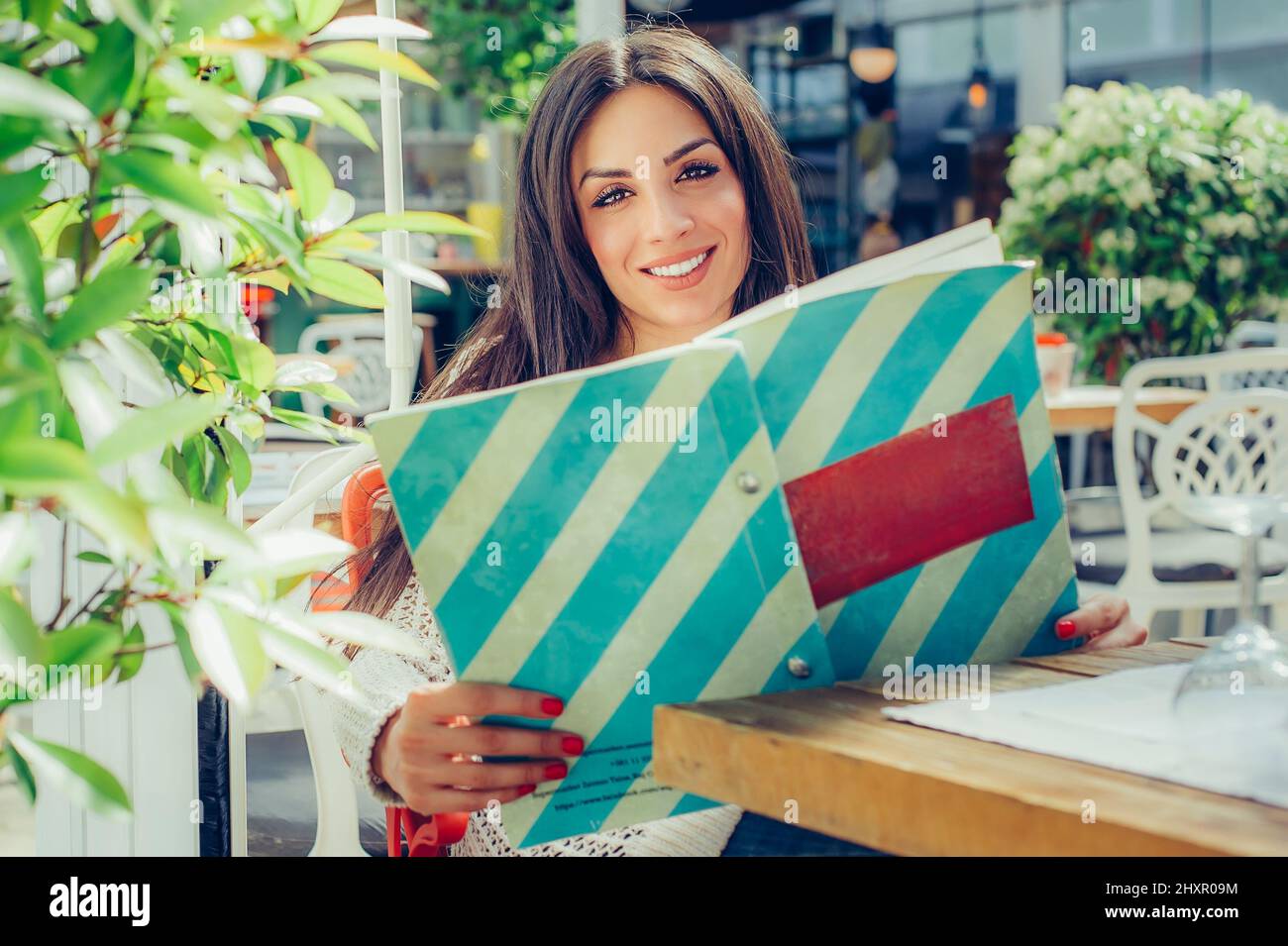 Beautiful woman looking at menu and ordering foods in restaurant. Close ...