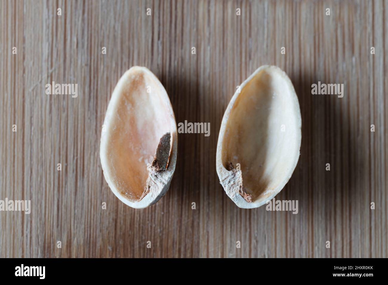 Top view of two empty pistachio shells on wood background Stock Photo ...